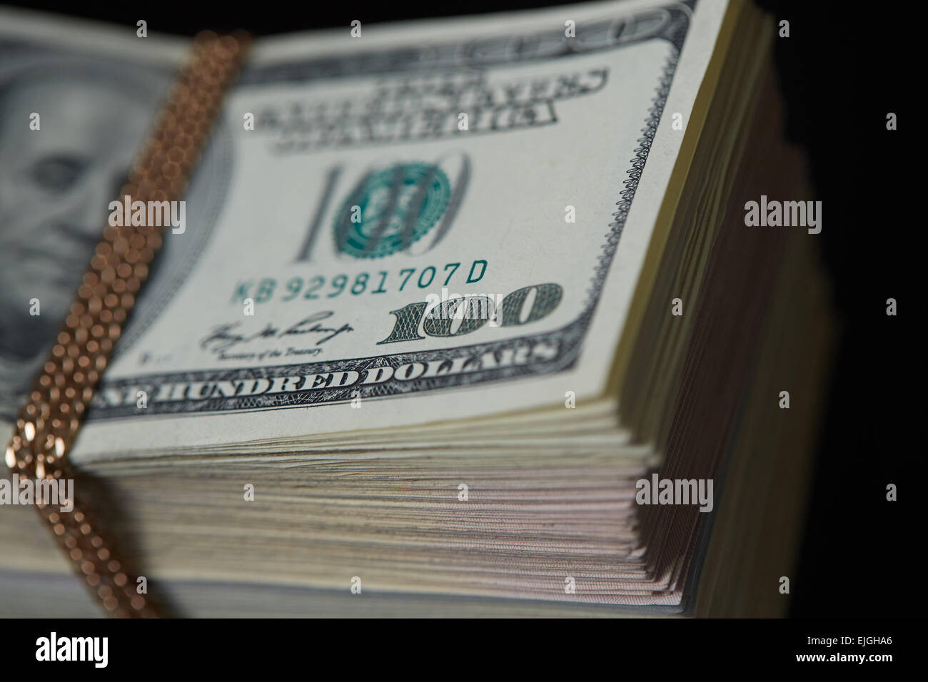 a bundle of money tied with gold chain Stock Photo - Alamy
