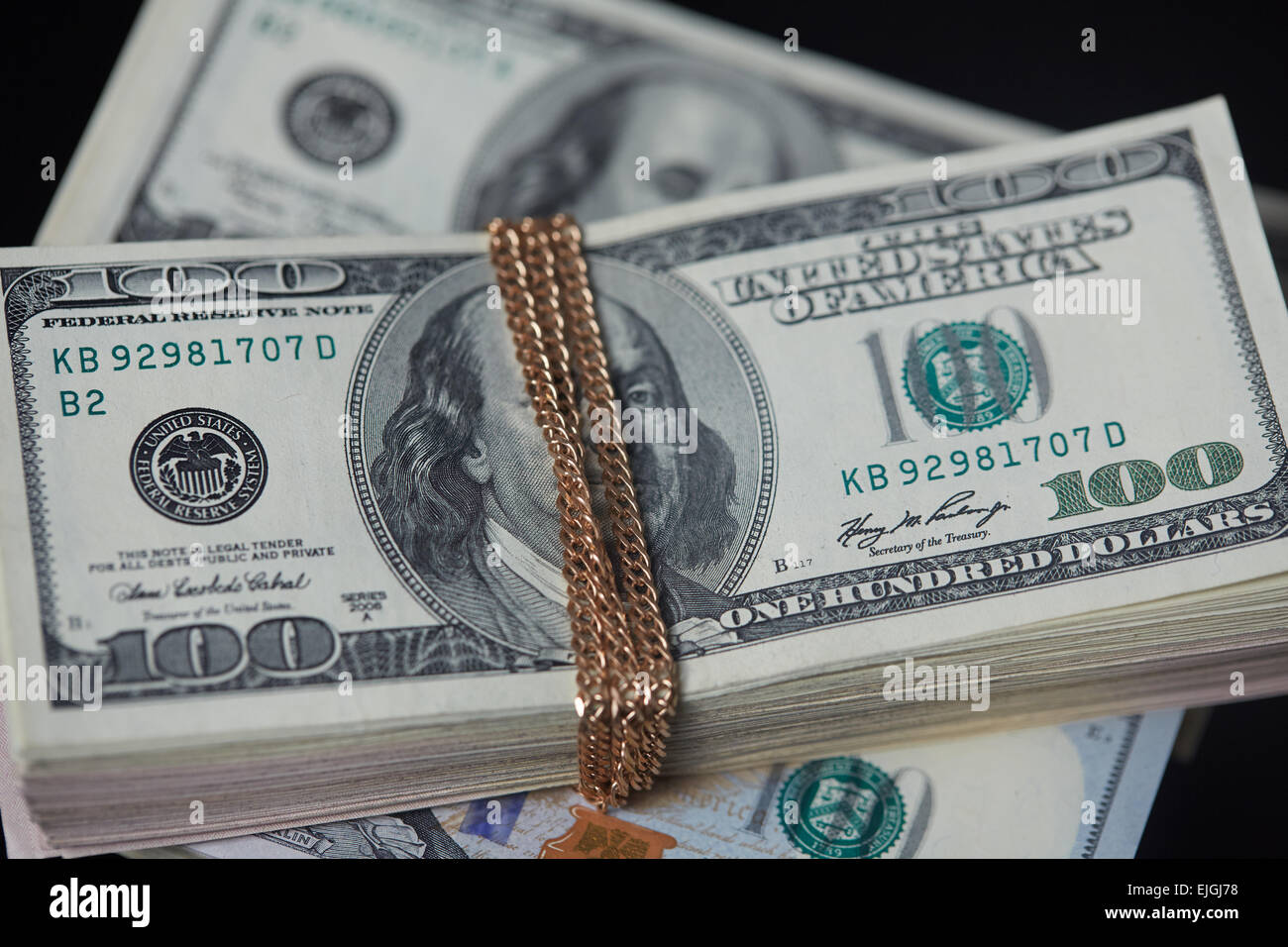 a bundle of money tied with gold chain Stock Photo - Alamy