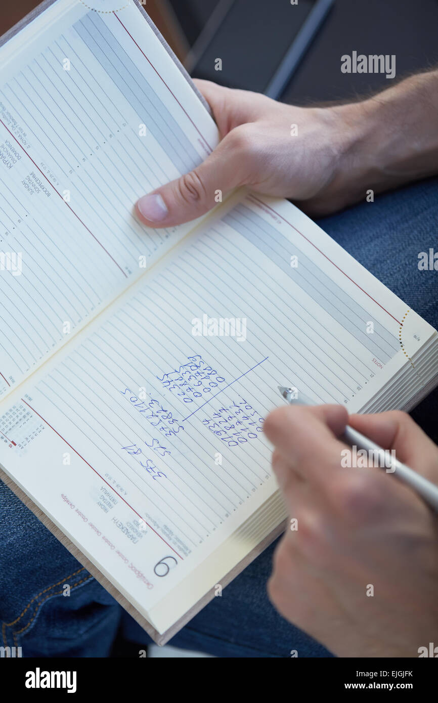 man writes in datebook Stock Photo - Alamy