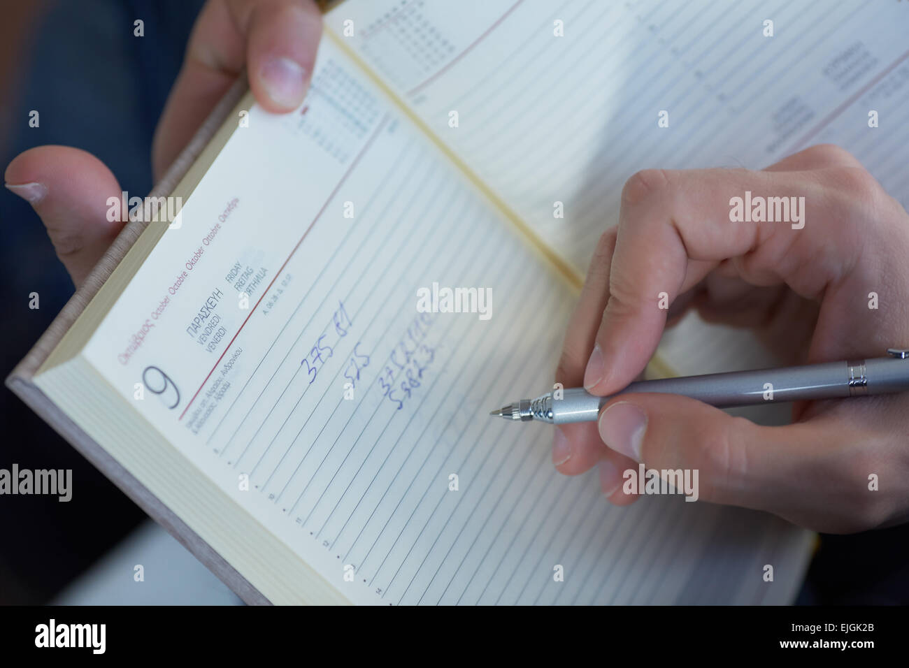 man writes in datebook Stock Photo - Alamy