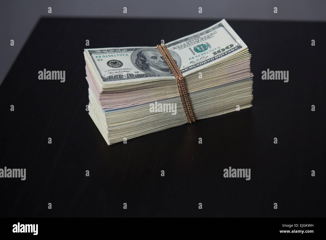a bundle of money tied with gold chain Stock Photo - Alamy