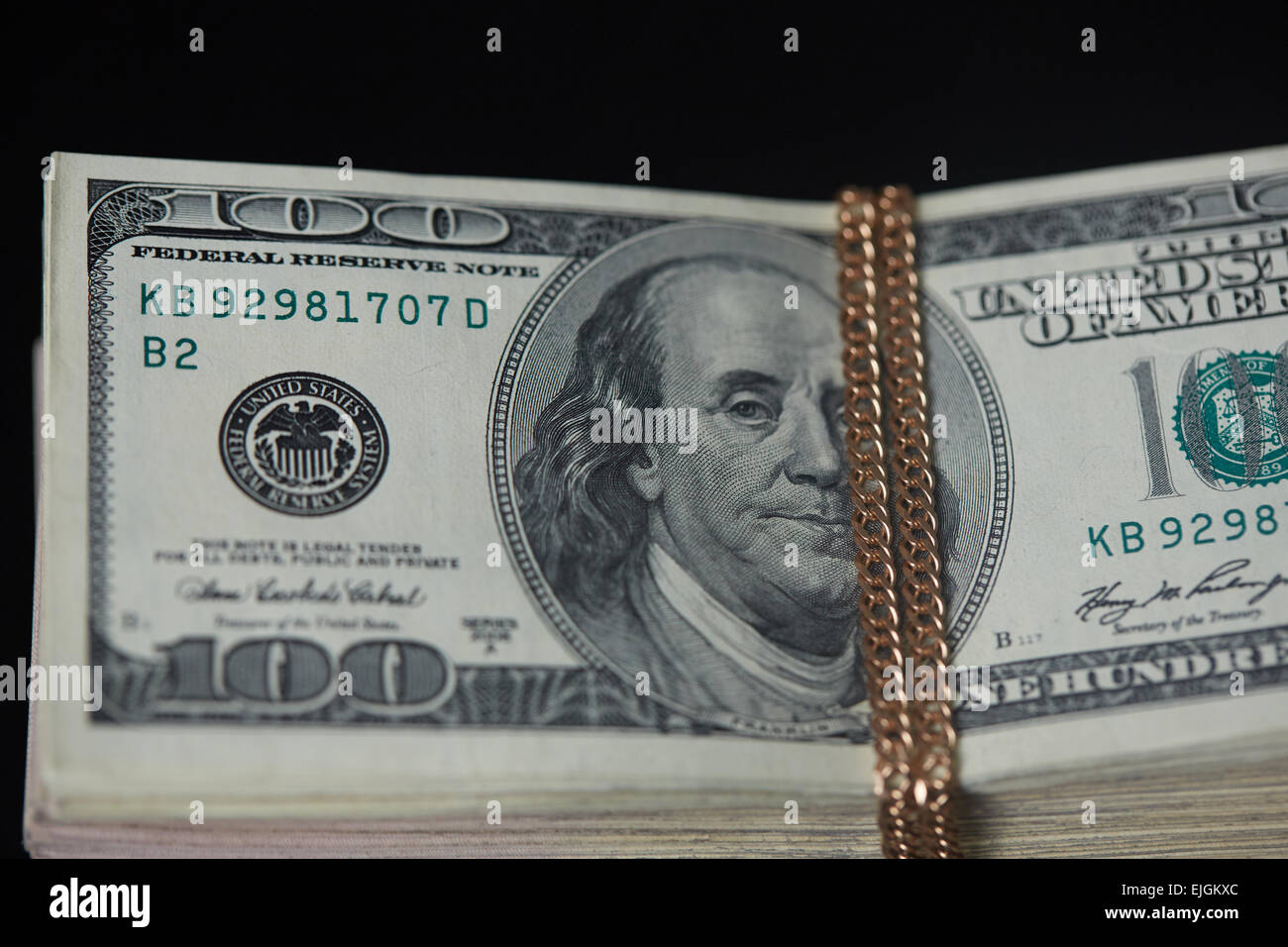 a bundle of money tied with gold chain Stock Photo - Alamy