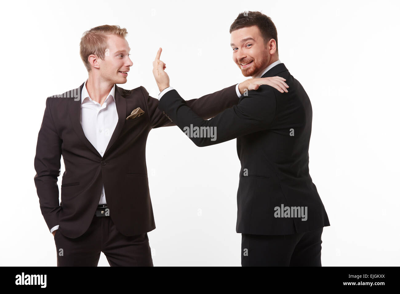 Two young men in suits talking having fun Stock Photo - Alamy