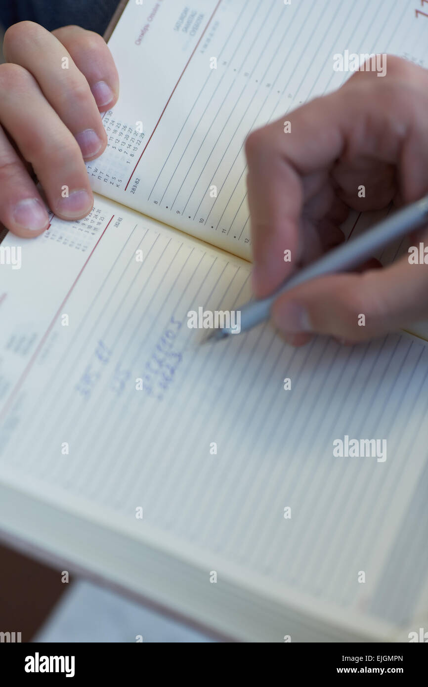 man writes in datebook Stock Photo - Alamy
