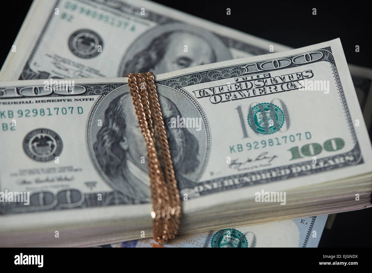 a bundle of money tied with gold chain Stock Photo - Alamy