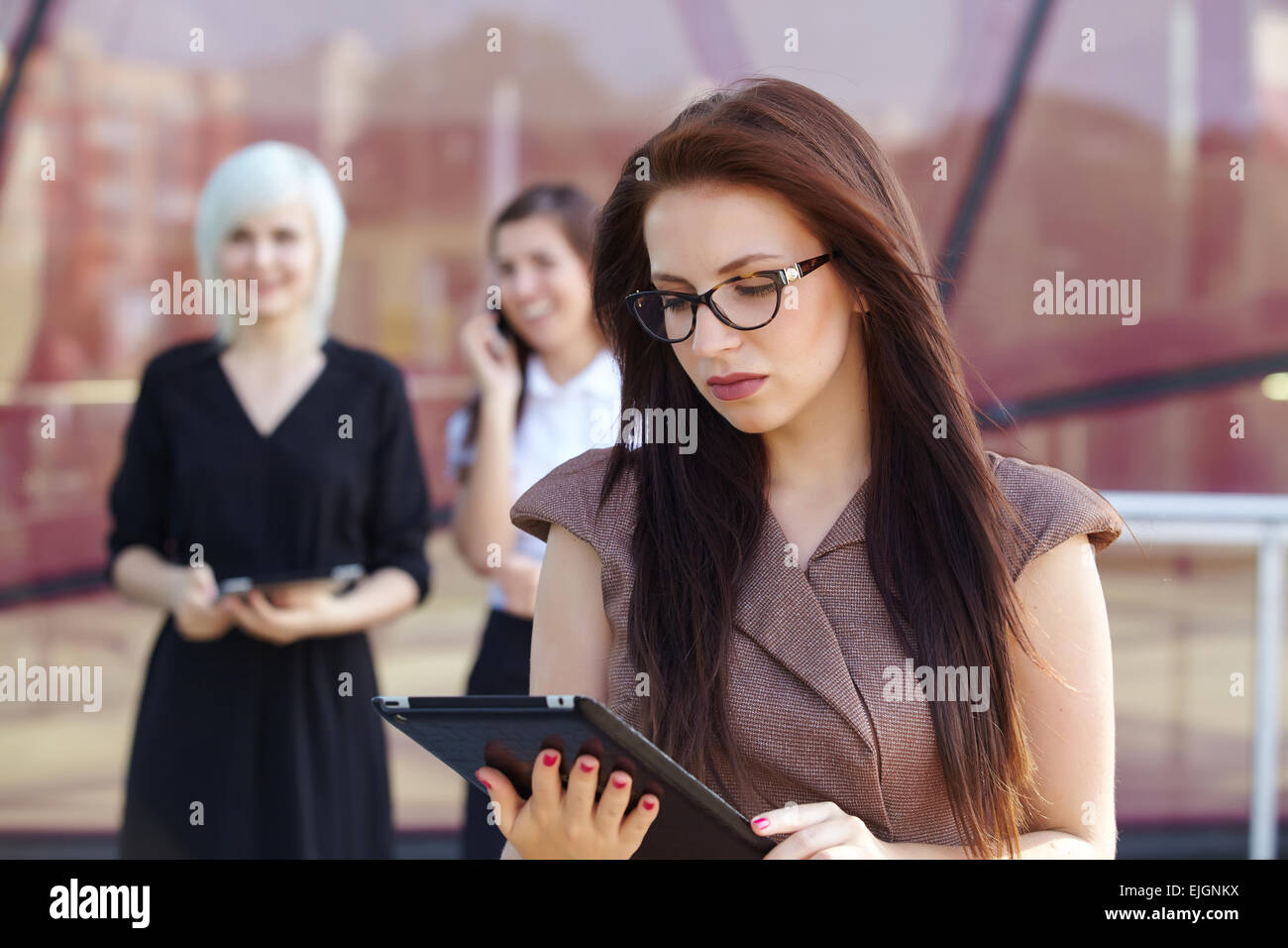 a group of businesswomеn from tablets on the street Stock Photo - Alamy