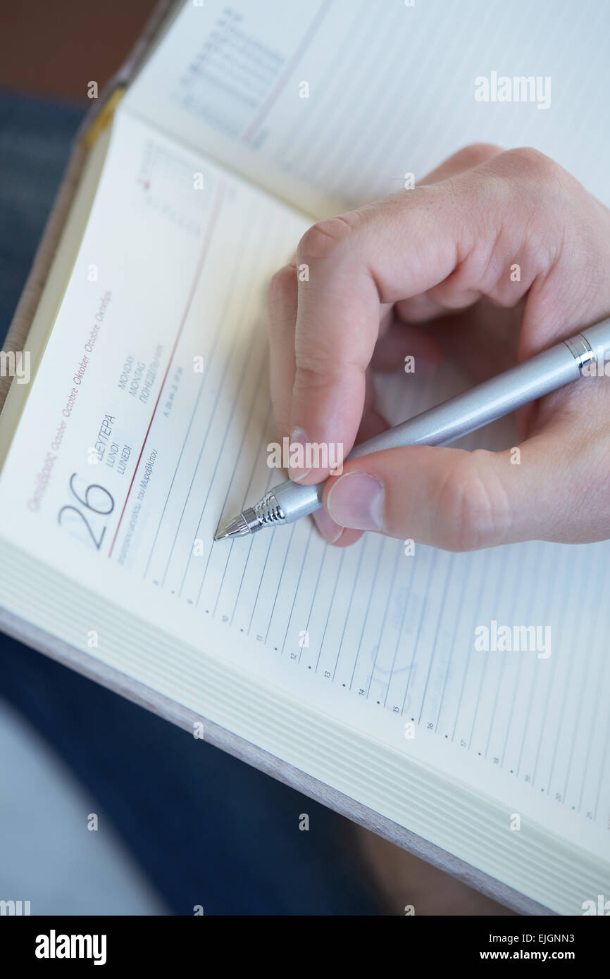 man writes in datebook Stock Photo - Alamy