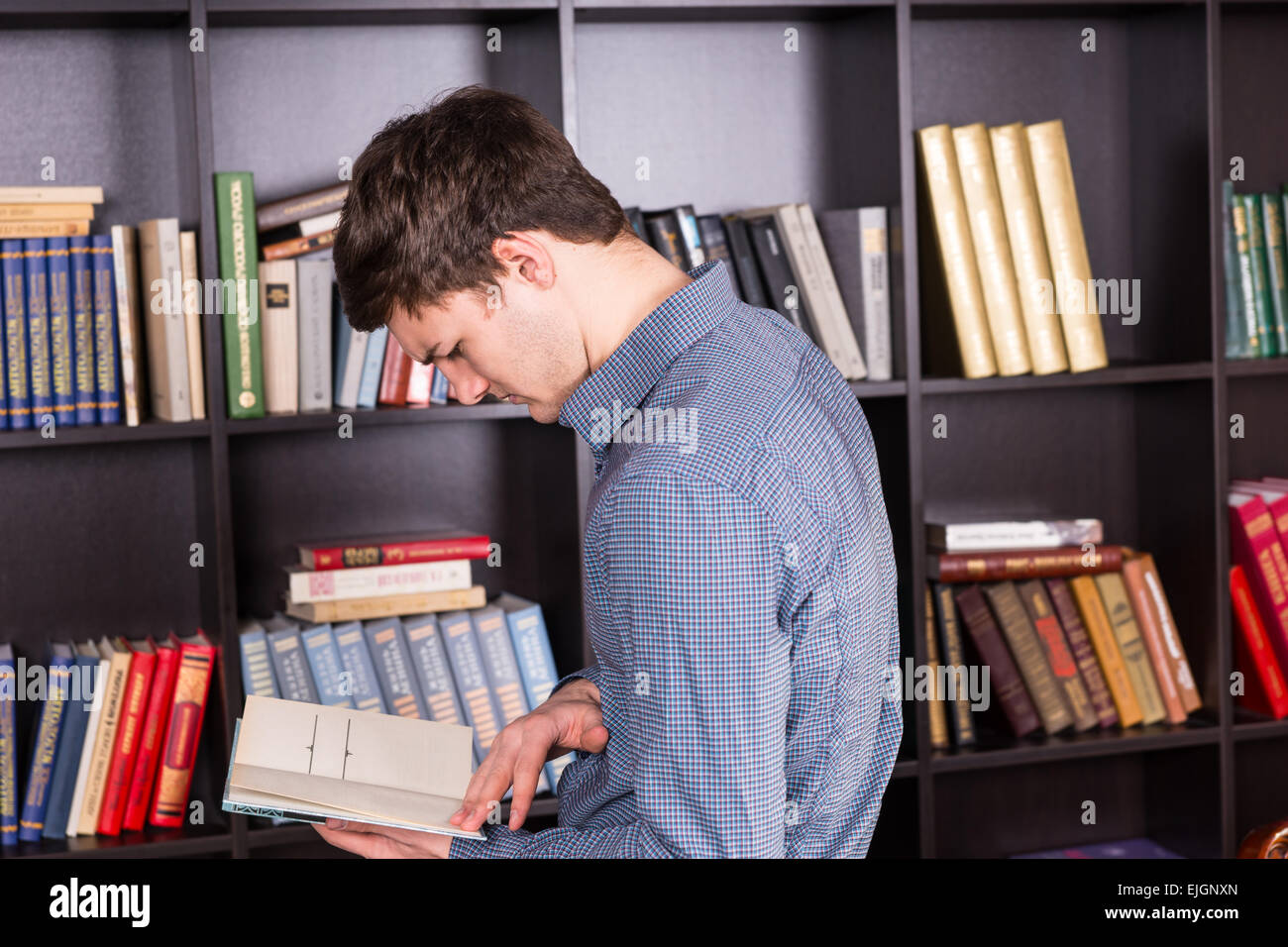 Close Up Serious Young Guy Reading a Book for Research In Front of the ...