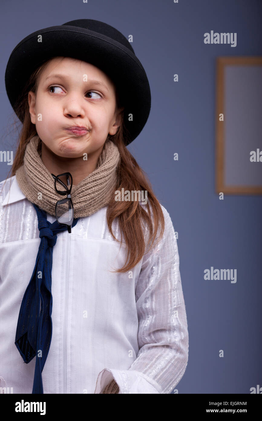 little girl thinking perplexed in a strange costume consisting in a hat ...