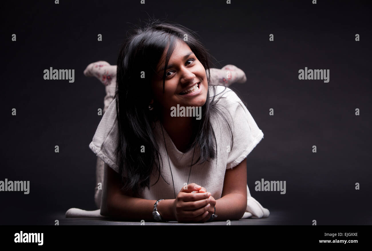 portrait of a prone girl on the floor smiling Stock Photo - Alamy