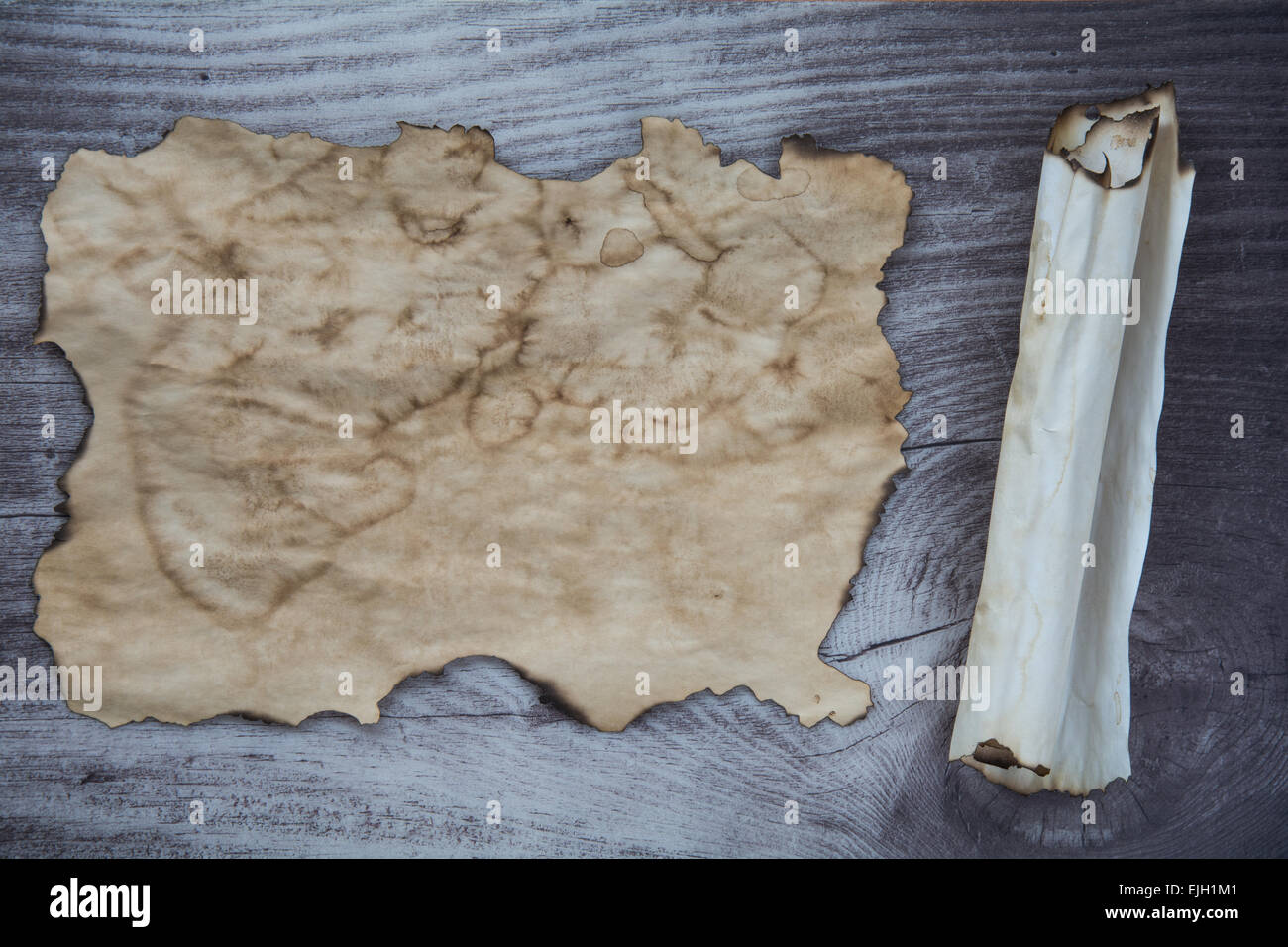 Piece of old paper and old paper roll on wooden background Stock Photo ...