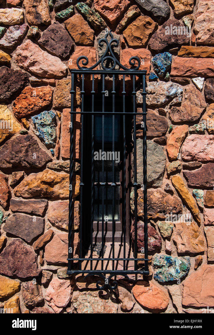 Ornate cast iron bars cover the window of a historic rock masonry ...