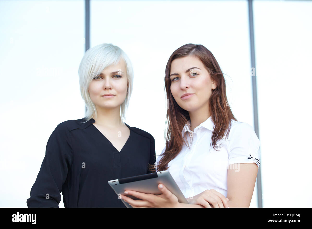 Two business woman with tablets Stock Photo - Alamy