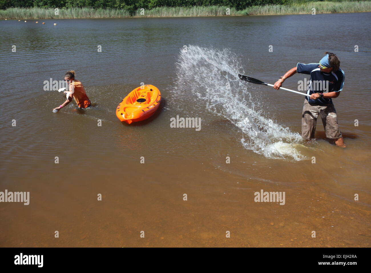 Man splashing a girl in a canoe Stock Photo - Alamy