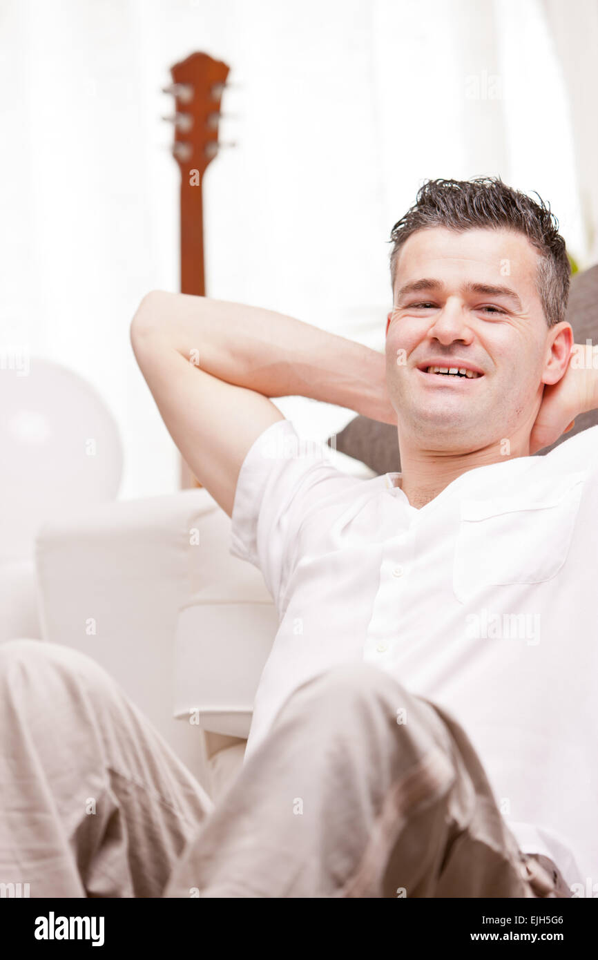relaxed man having finally his time off in his living room and his ...