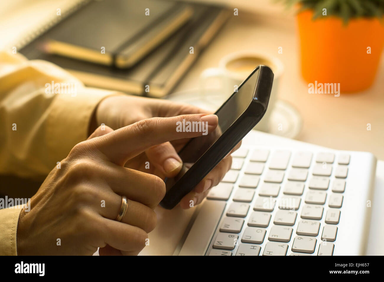 Woman hands touching smartphone and keyboard in background Stock Photo ...