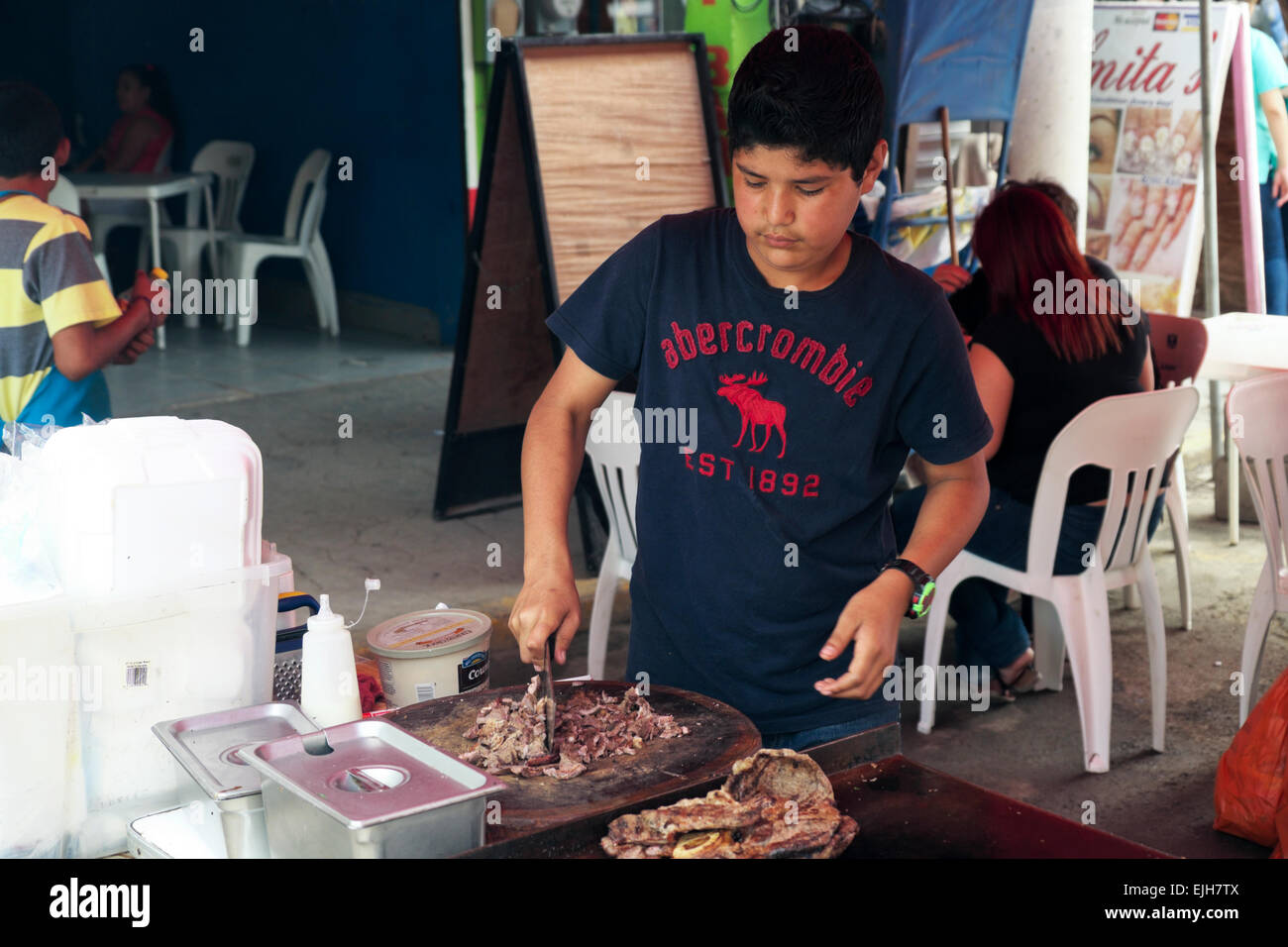 Teenage hispanic boy chops meat hi-res stock photography and images - Alamy