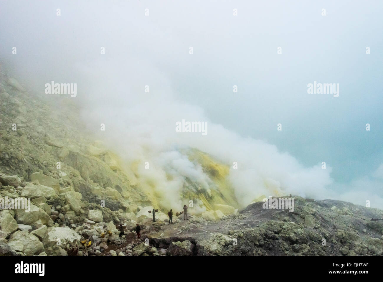Miners carrying sulfur amid sulfur gas, Ijen volcano, East Java ...