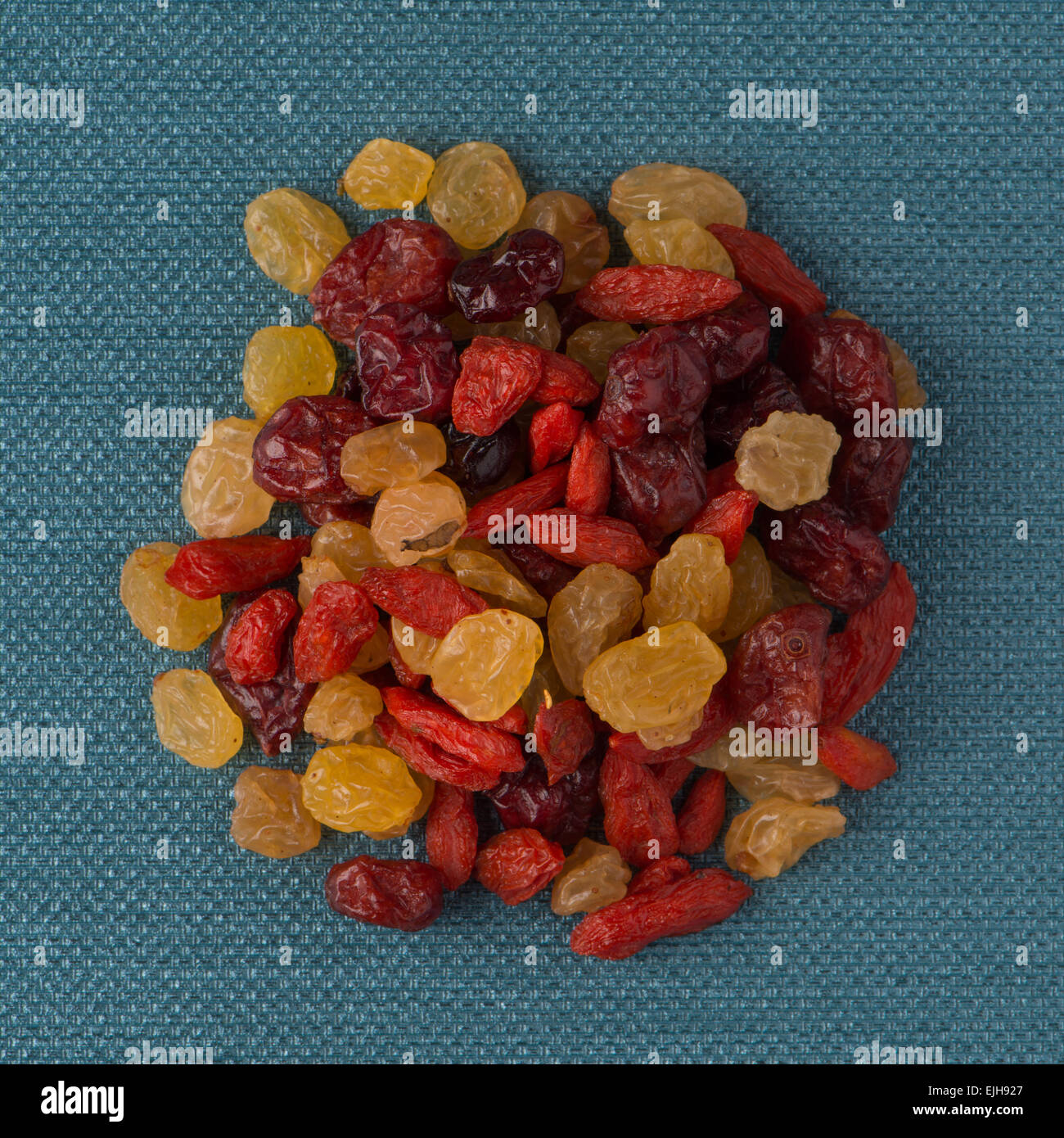 Top view of circle of mixed dried fruits against blue vinyl background ...