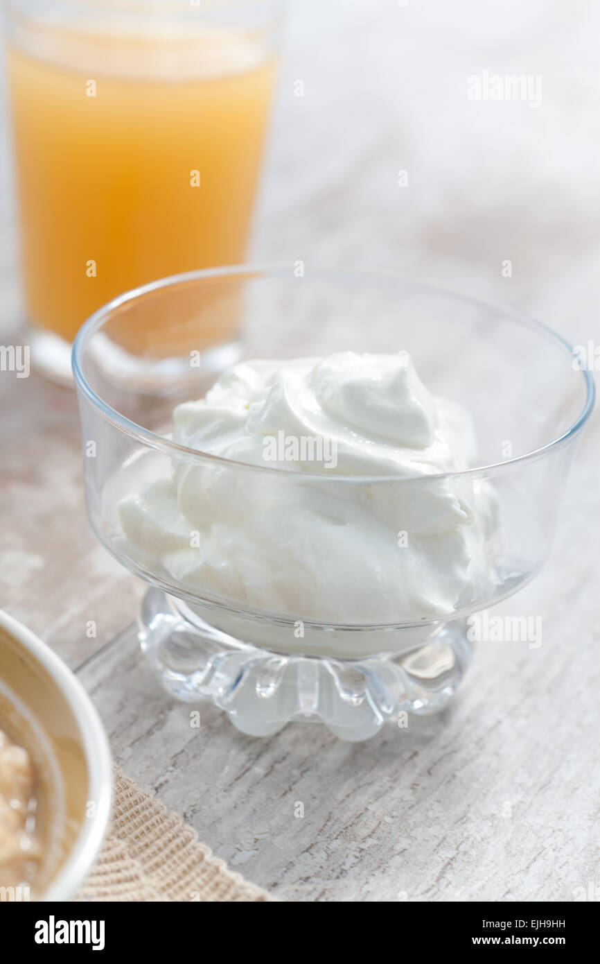 close up view of glass with fresh sour cream on color back Stock Photo ...