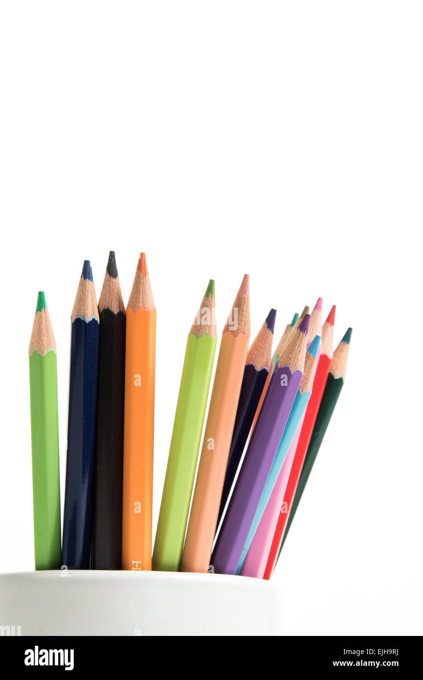 A group of multi colored pencils in a white cup on an isolated ...
