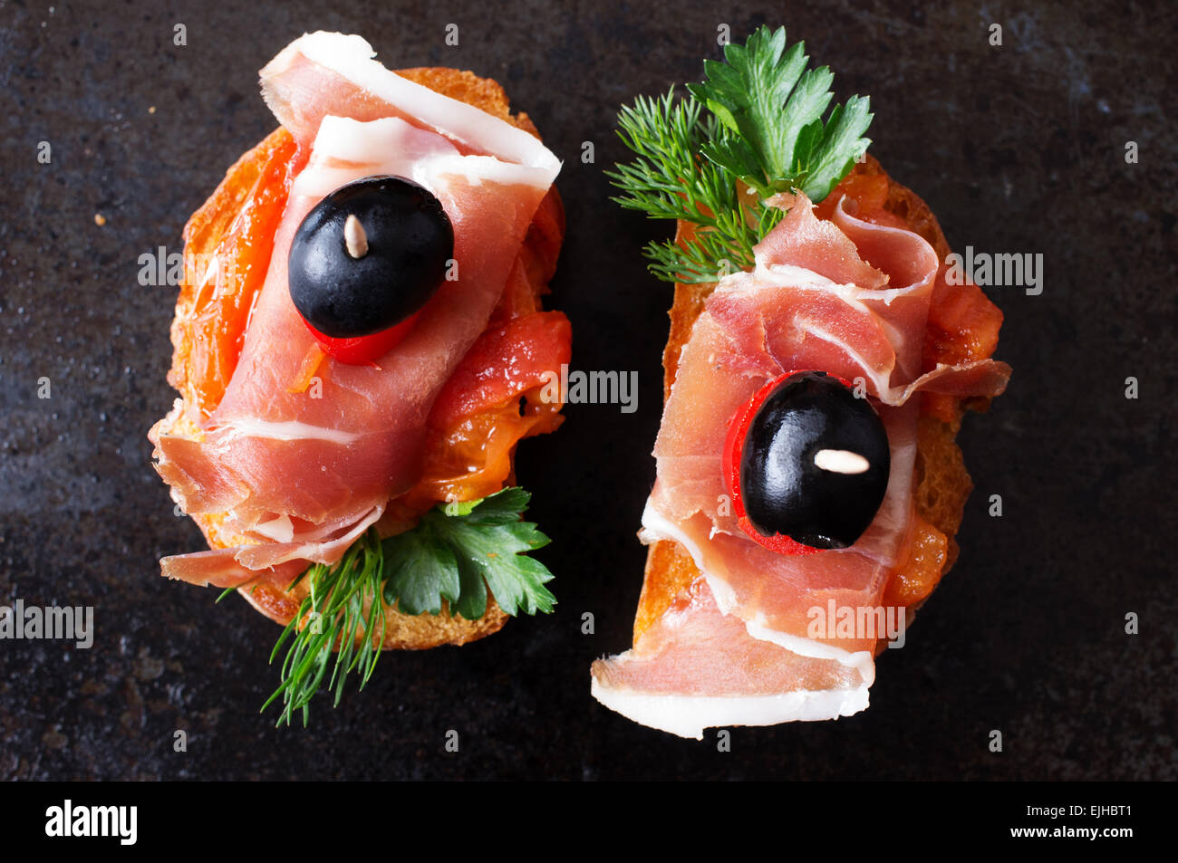 Spanish appetizer with jamon on a black background top view Stock Photo ...