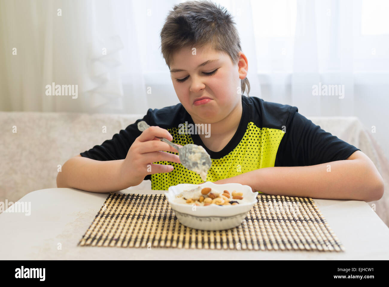 Teenager boy refuses to eat oatmeal for breakfast Stock Photo - Alamy