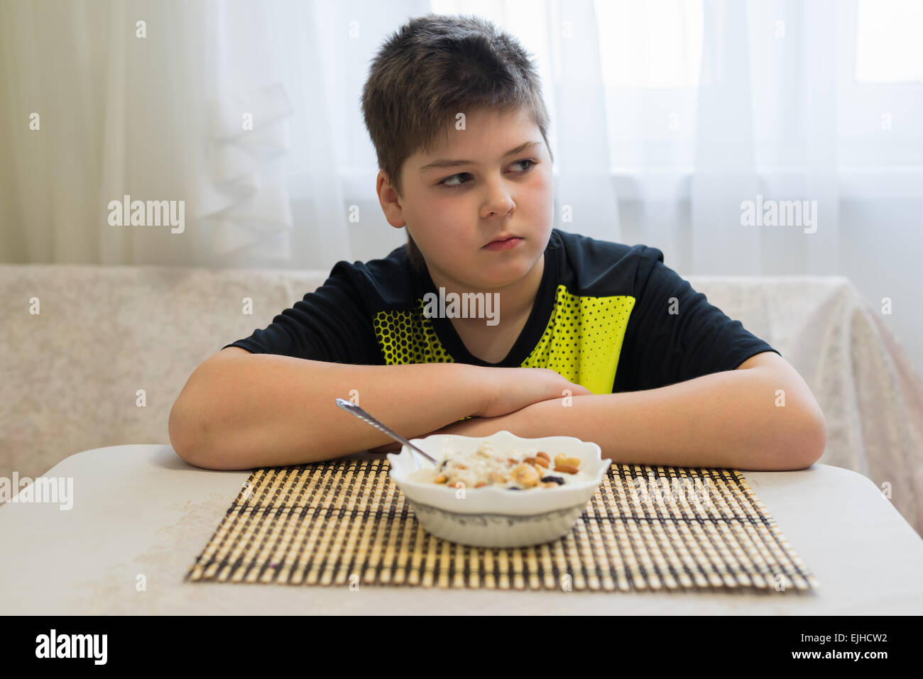Teenager boy refuses to eat oatmeal for breakfast Stock Photo - Alamy