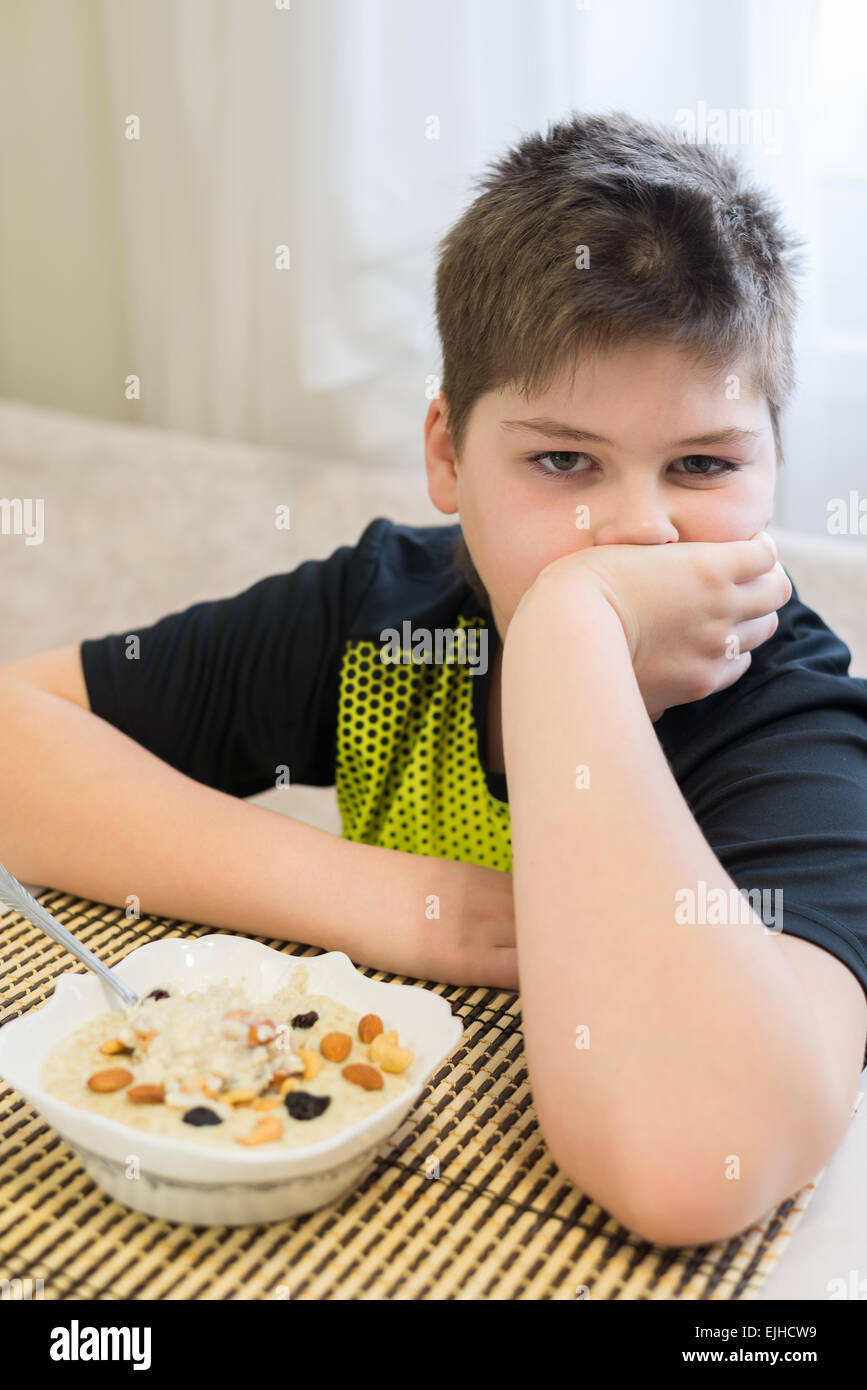 Teenager boy refuses to eat oatmeal for breakfast Stock Photo - Alamy