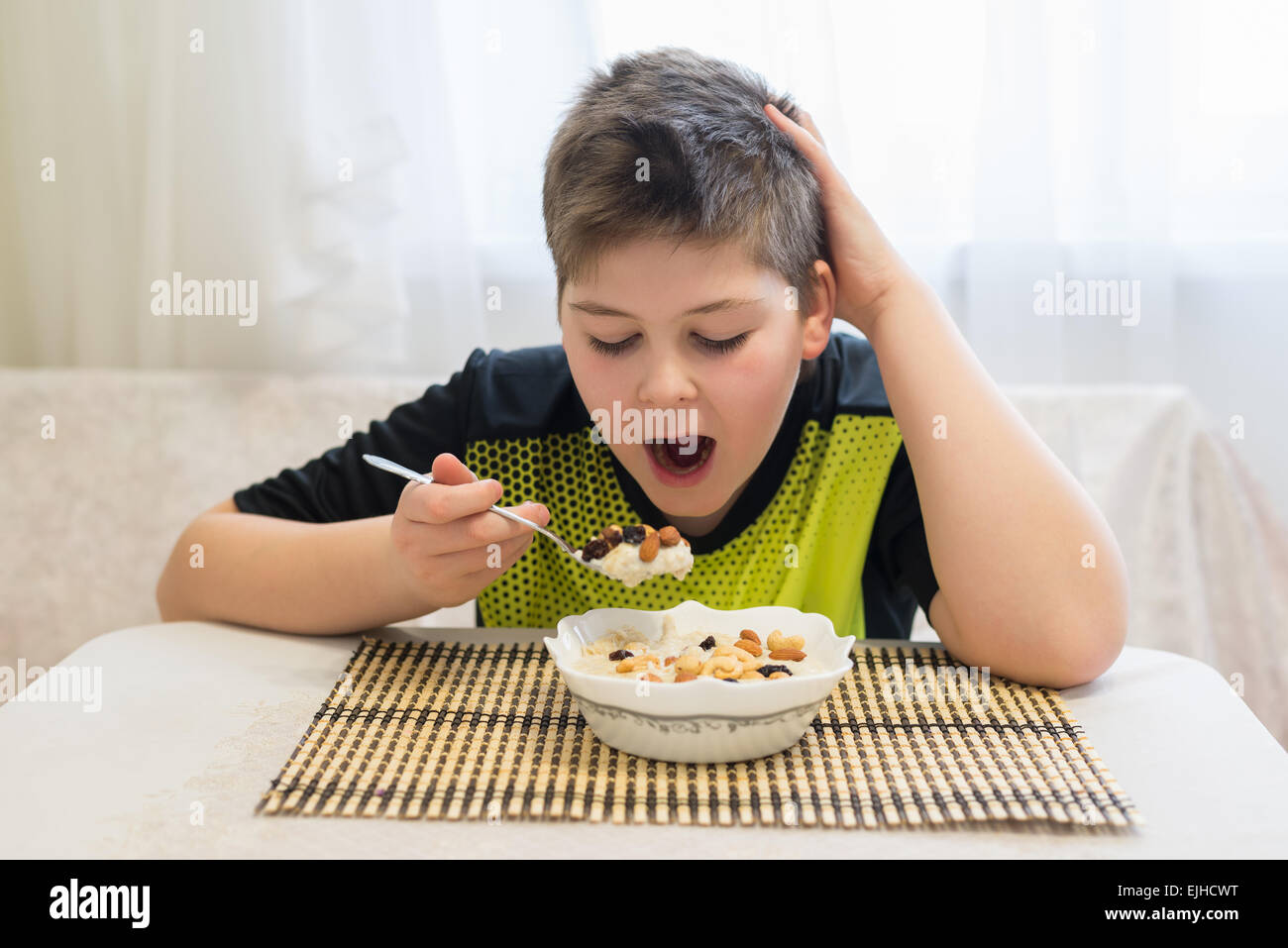 Teenager boy has oatmeal for breakfast Stock Photo - Alamy