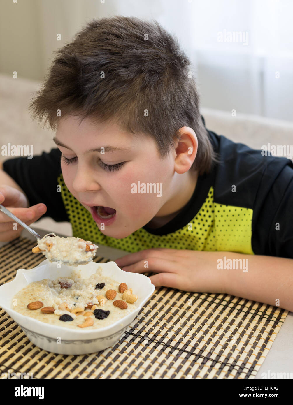 Teenager boy has oatmeal for breakfast Stock Photo - Alamy