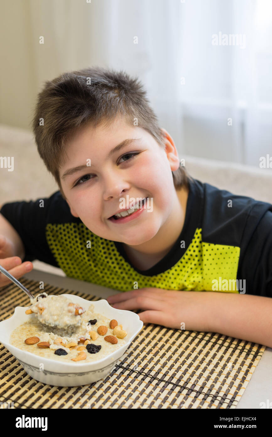 Teenager boy has oatmeal for breakfast Stock Photo - Alamy
