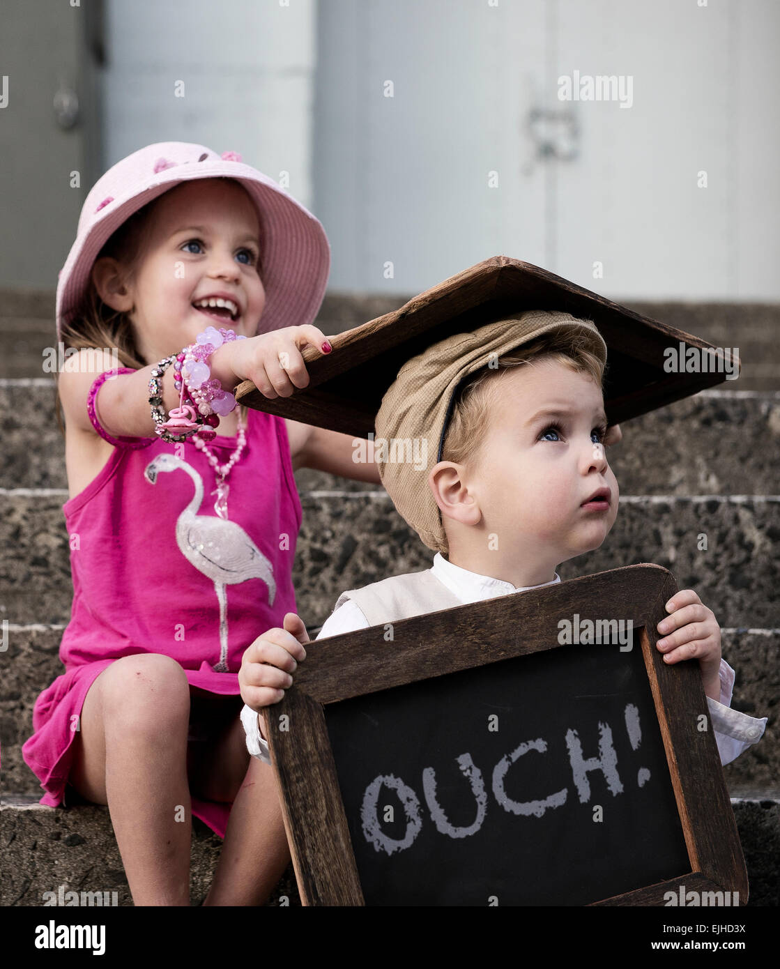 Naughty Sister Hits Her Brother Over The Head With Chalkboard Stock