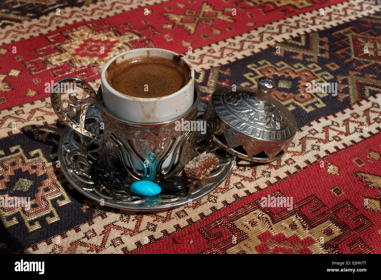 Traditional Turkish coffee in silver cup, with sweets and candies on ...
