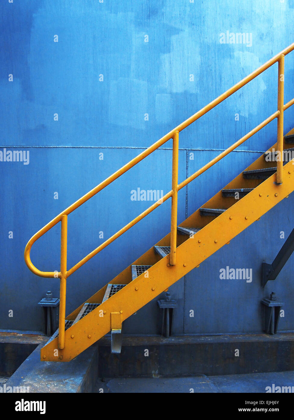 Yellow iron stairs on the bluish background Stock Photo - Alamy