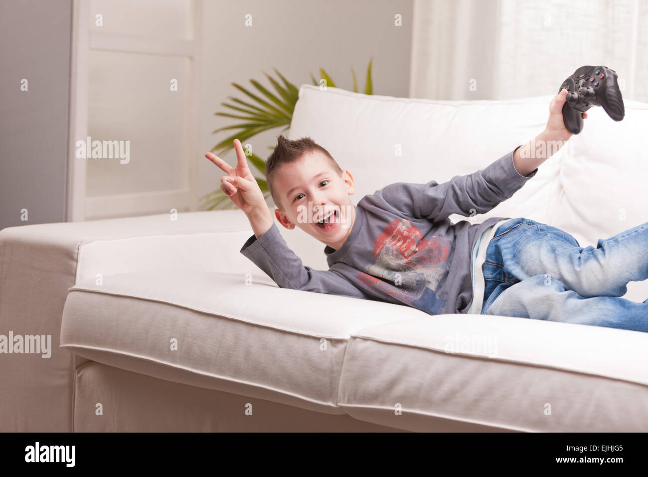 Kid having fun with video games in a brighly lit living room Stock ...