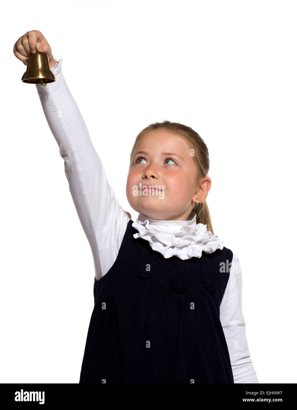 Young school girl ringing a golden bell on an outstretched arm on white ...