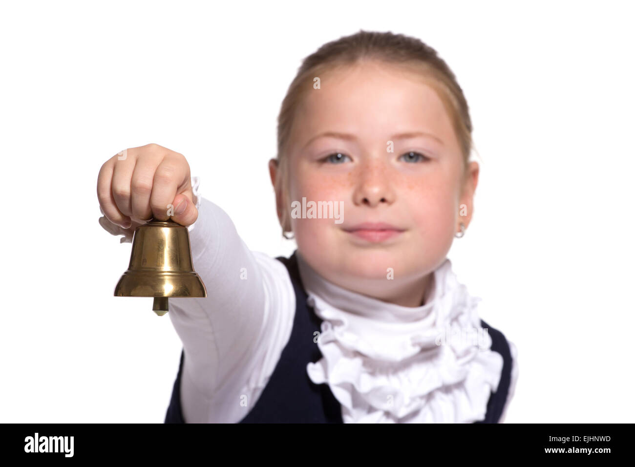 Young school girl ringing a golden bell on white background focused on ...