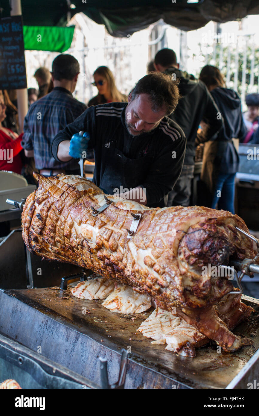 Man carving a large piece of meat at Borough Market, London, England ...