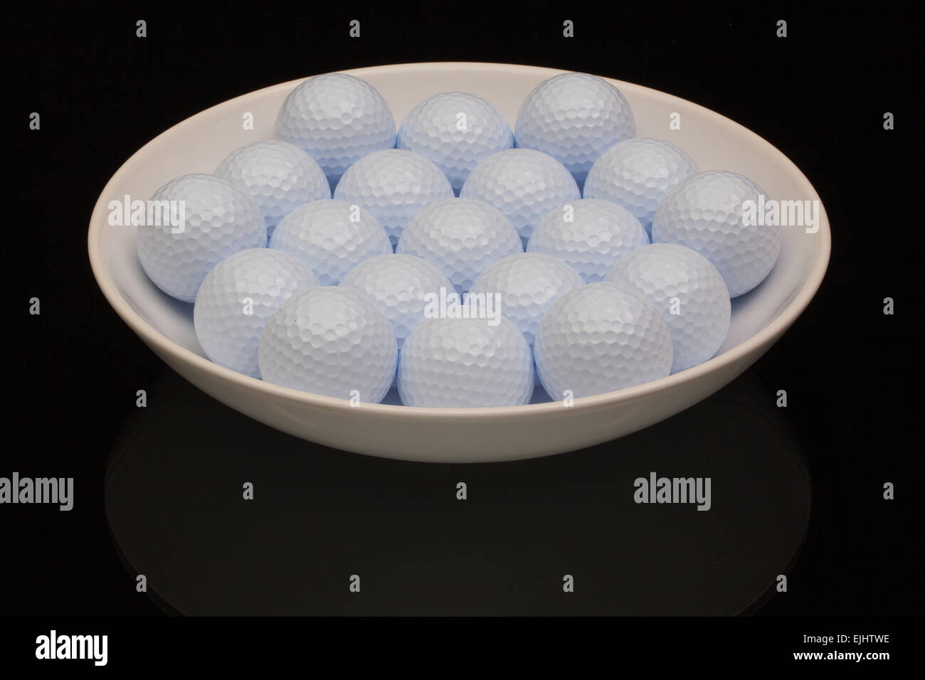 White ceramic bowl full of golf balls Stock Photo - Alamy