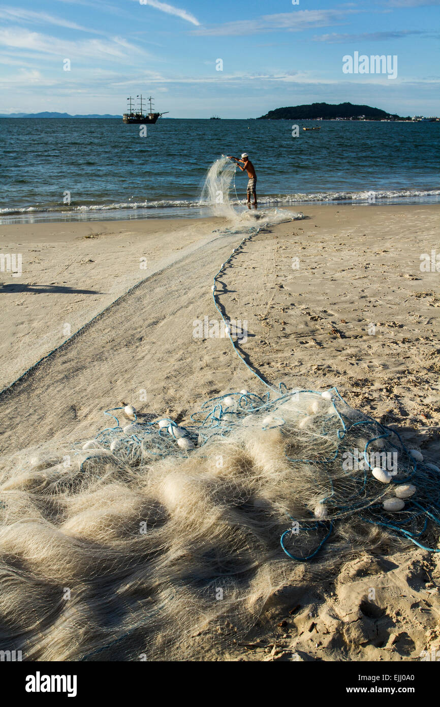 Fisherman handling a fishing net at Cachoeira do Bom Jesus Beach ...