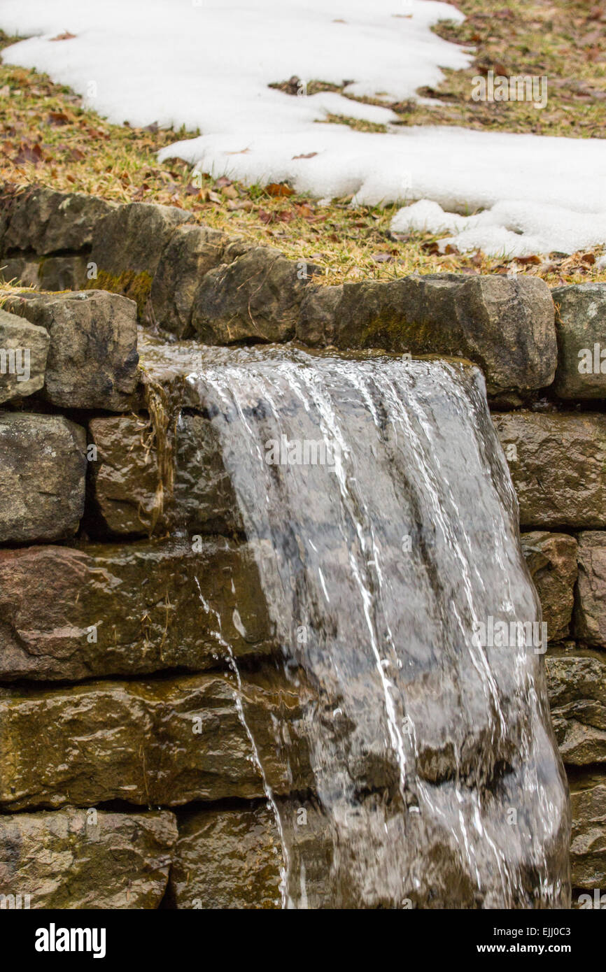 A sheet of water falls over a stone wall Stock Photo - Alamy