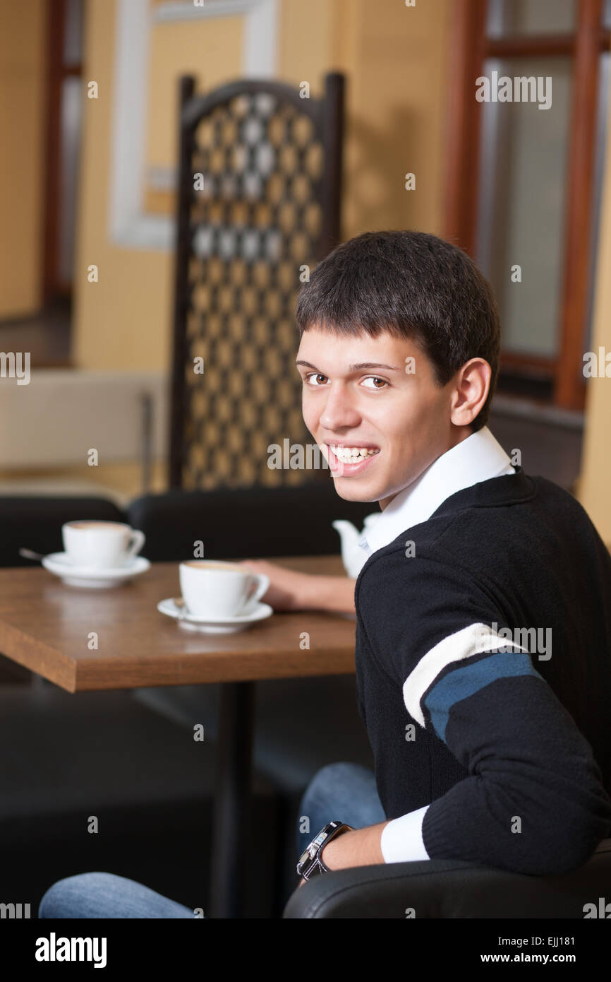 Young man across table with cup of coffee Stock Photo - Alamy