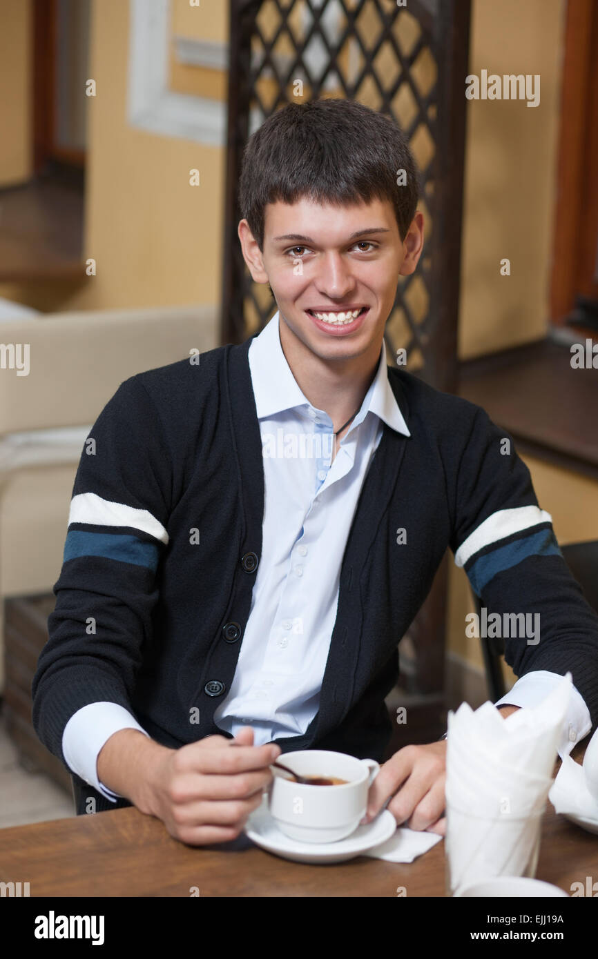 Young man across table with cup of coffee Stock Photo - Alamy