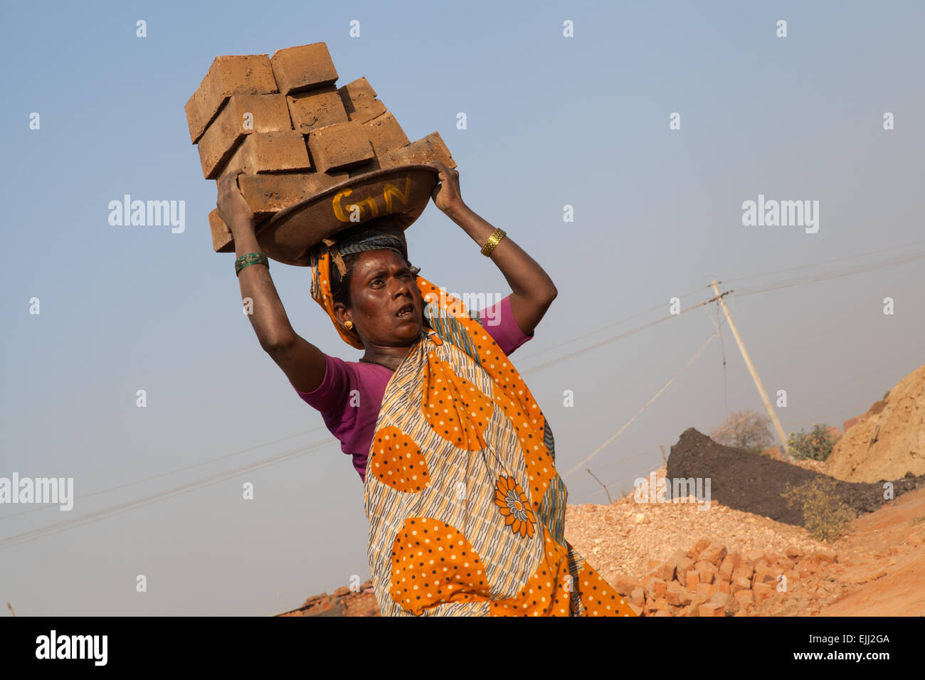 Female worker carrying bricks on her head Stock Photo - Alamy