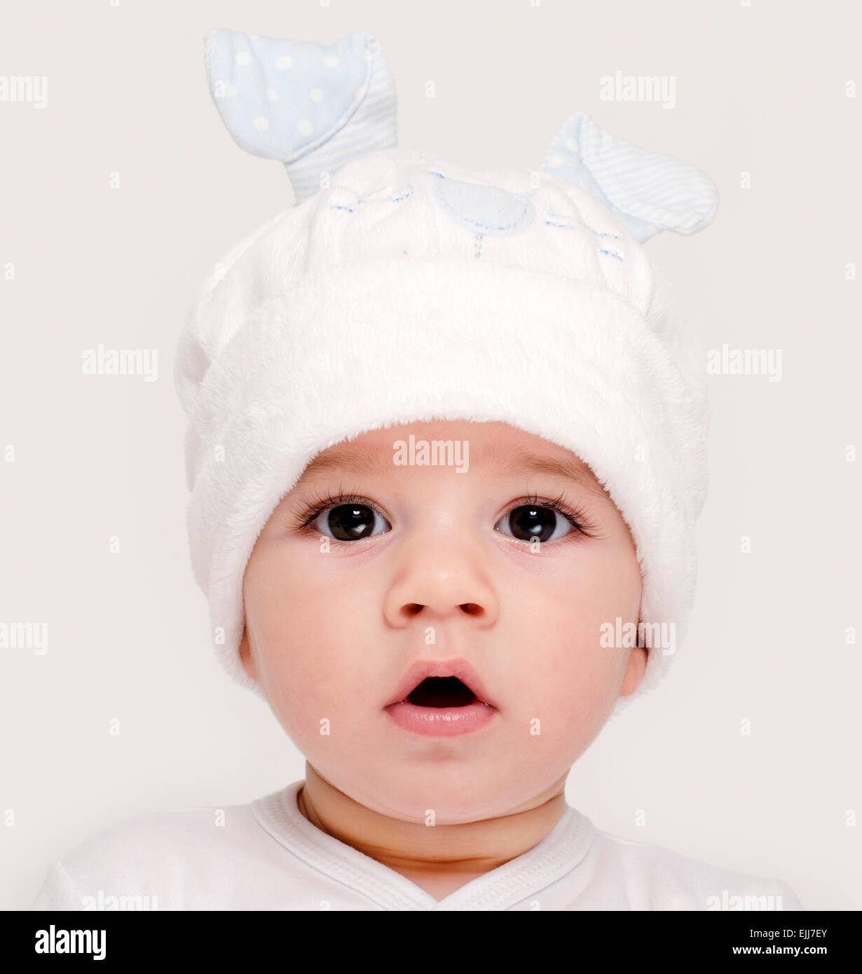 Innocent baby wearing a white hat looking adorable. Kid dressed for ...