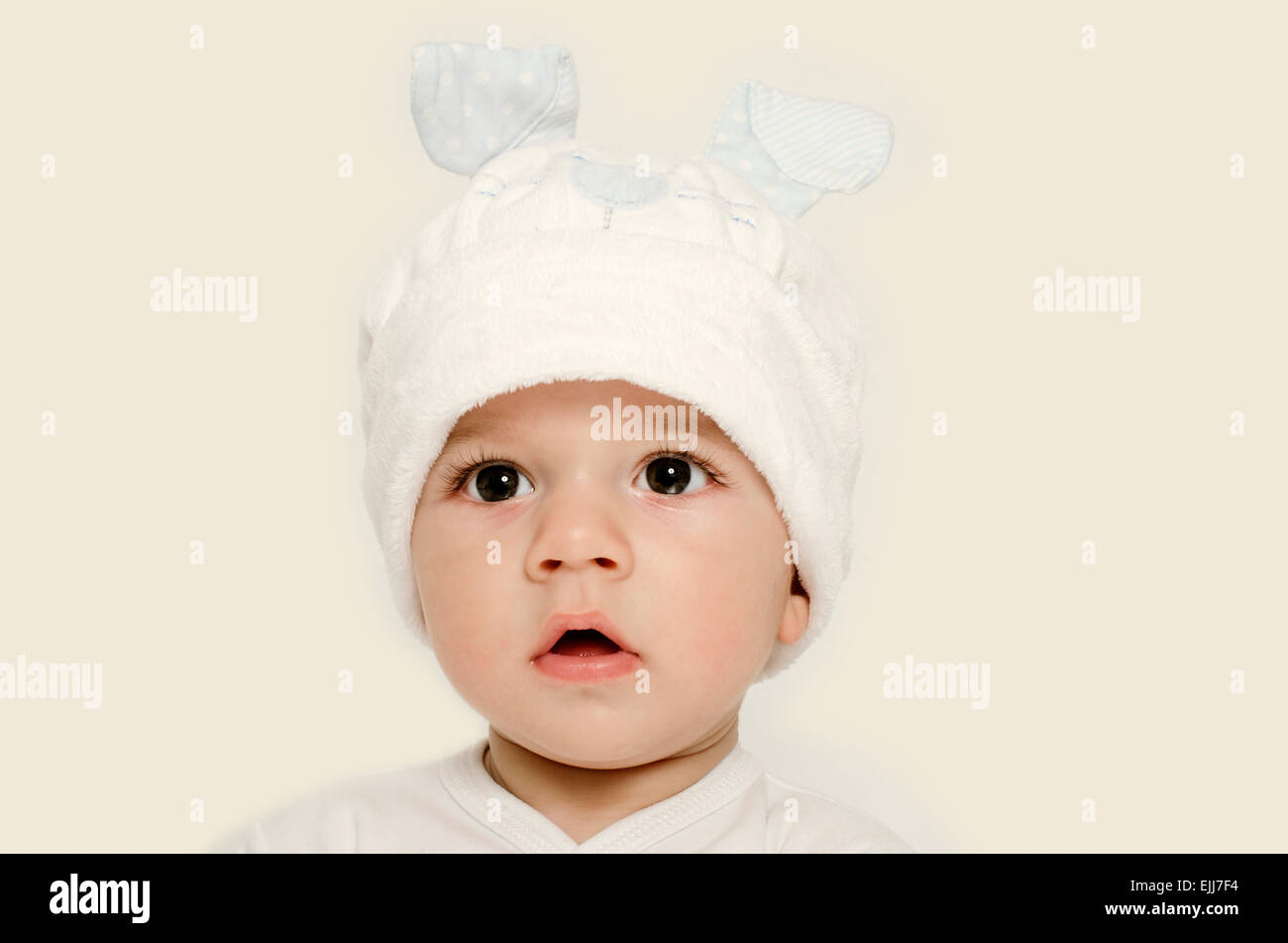 Innocent baby wearing a white hat looking adorable. Kid dressed for ...