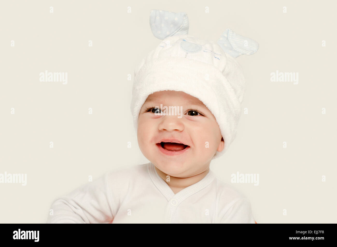 Innocent baby wearing a white hat looking adorable. Kid dressed for ...