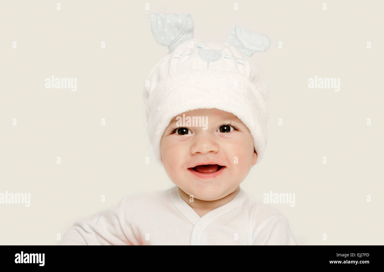 Innocent baby wearing a white hat looking adorable. Kid dressed for ...