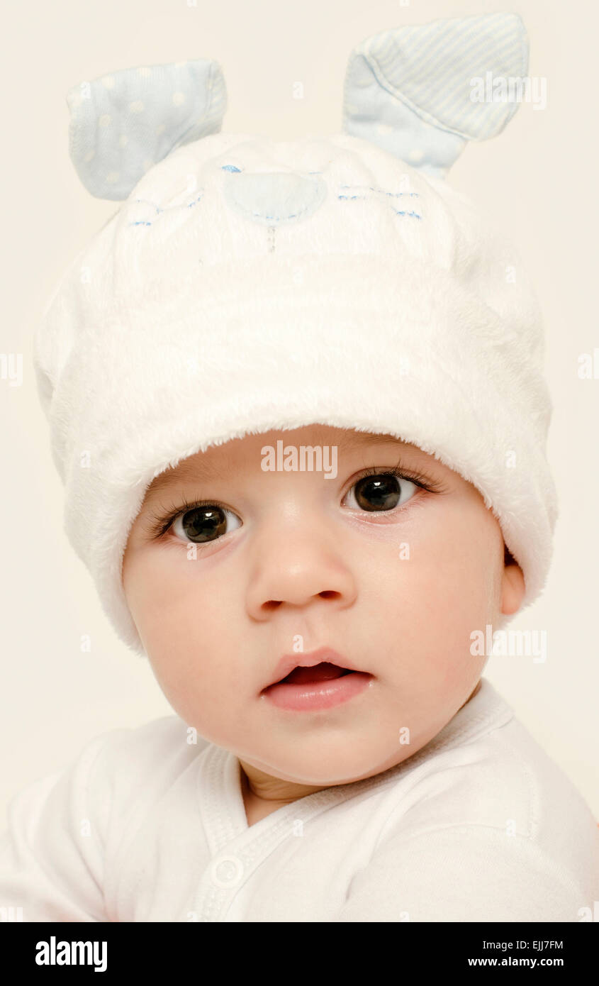 Innocent baby wearing a white hat looking adorable. Kid dressed for ...